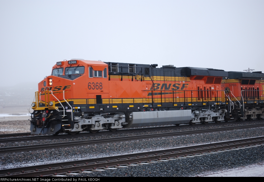 BNSF 6368 rolls eastward towards the entrance to BNSF yard as a rear DPU.